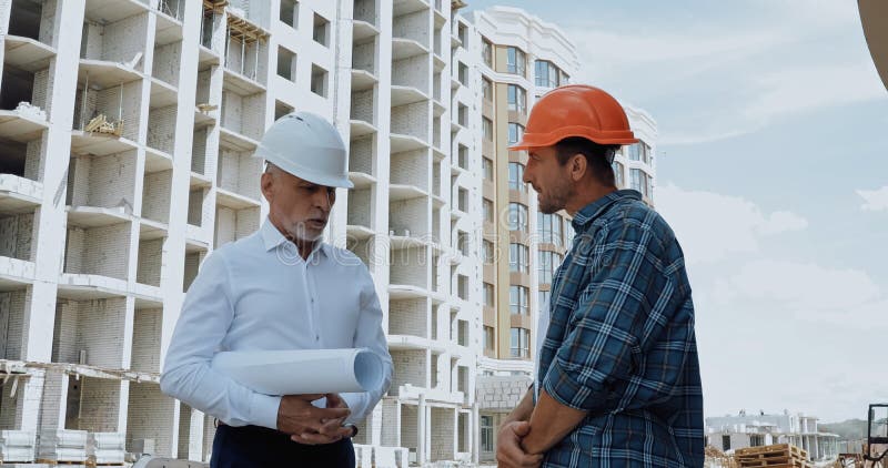 Engineer with Blueprints Having Conversation with Stock Photo - Image ...