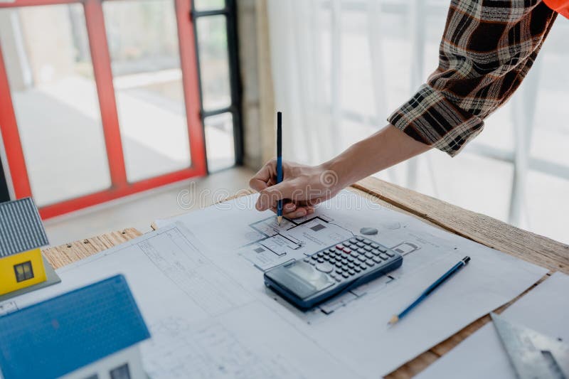 Engineer Brainstorming and Measuring for Cost Estimating on Blueprint ...