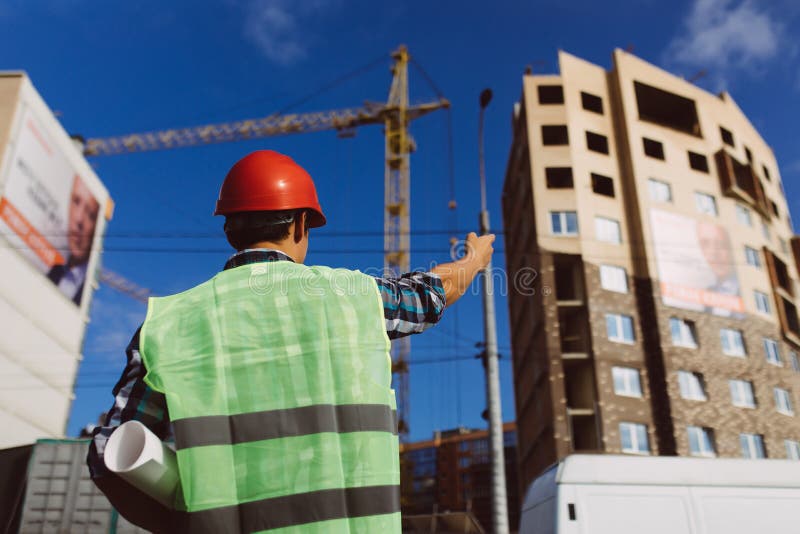 Young Engineer Builder with Blueprint Plan at Construction Site ...
