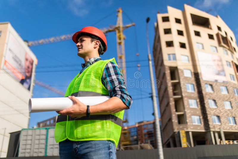 Young Engineer Builder with Blueprint Plan at Construction Site ...