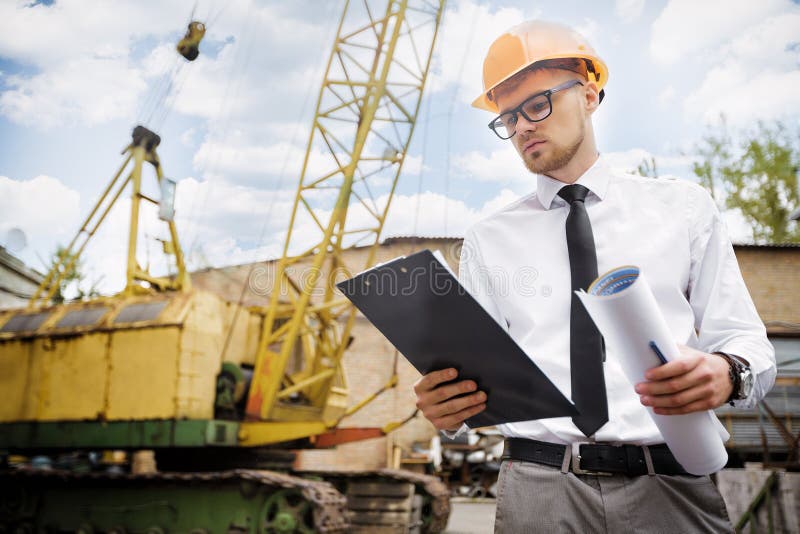 Engineer Builder in a Helmet Holds Drawings at Construction Site Stock ...