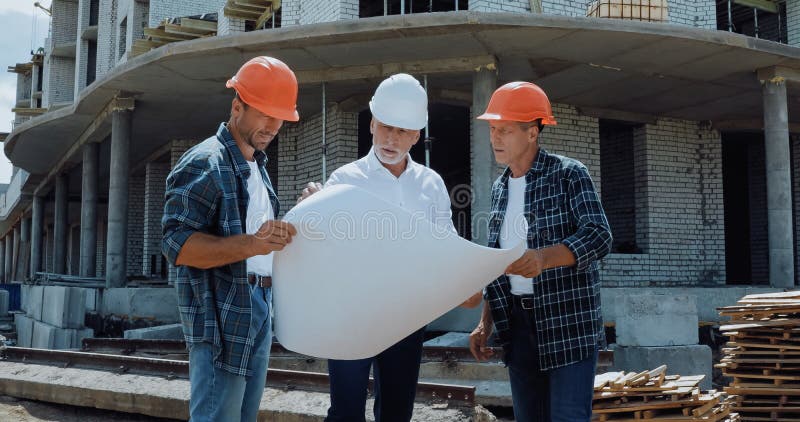 Builders Talk about Blueprints Stock Image - Image of adult, builder ... Builders Talk about Blueprints Stock Image - Image of adult, builder ...