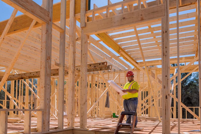 An Engineer Checking Quality of the Wooden Frame Using Blueprint Plan ...