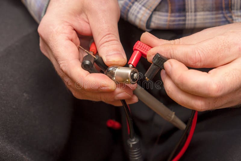 Engineer Checks a Light Bulb for Efficiency with the Help of Multimeter ...
