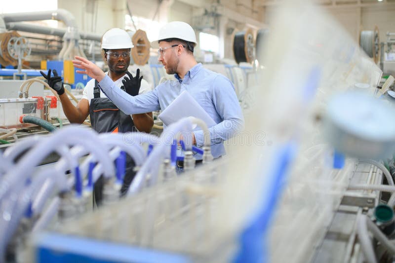 An Engineer Communicates with a Worker on a Production Line Stock Image ...