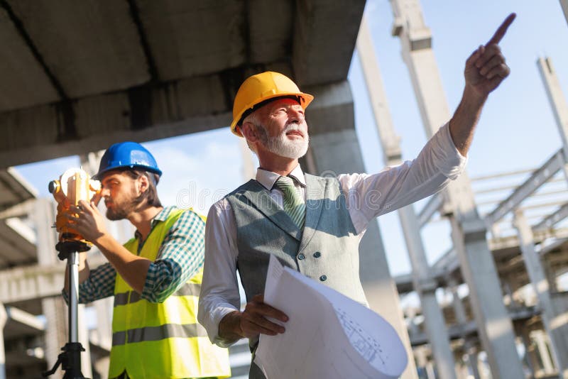 Engineer and Construction Site Manager Dealing with Blueprints and ...