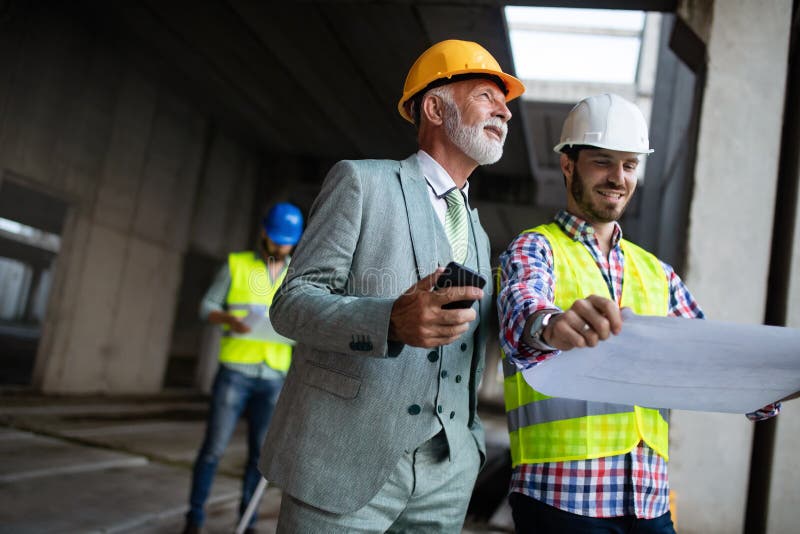 Engineer and Construction Site Manager Dealing with Blueprints and ...