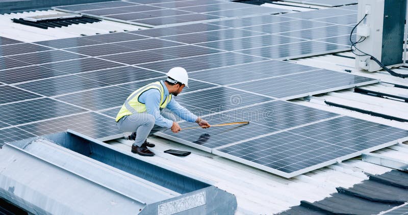 Engineer or Contractor Measuring Solar Panels on a Roof of a Building ...