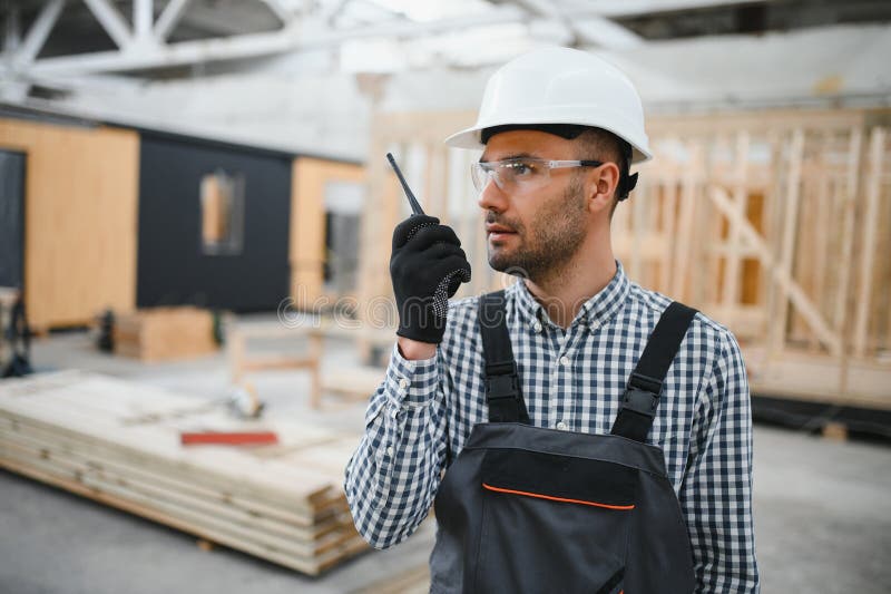 An Engineer Controls the Production of Modular Houses and Uses a Walkie ...