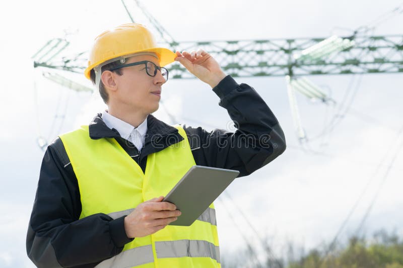 Engineer with Digital Tablet Works on a Field of Wind Turbines Stock ...