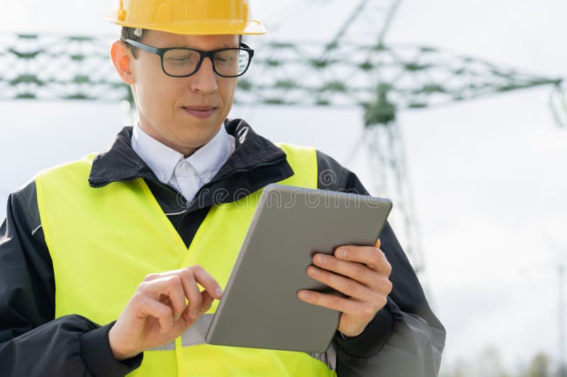Engineer with Digital Tablet on a Background of Power Line Tower Stock ...