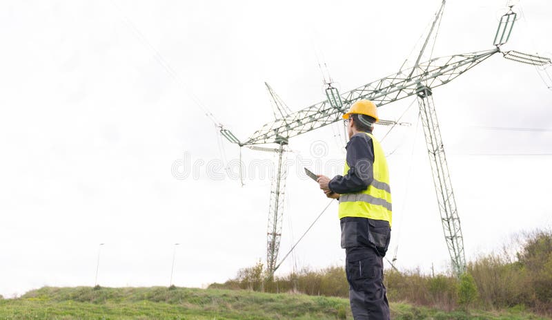Engineer with Digital Tablet on a Background of Power Line Tower Stock ...