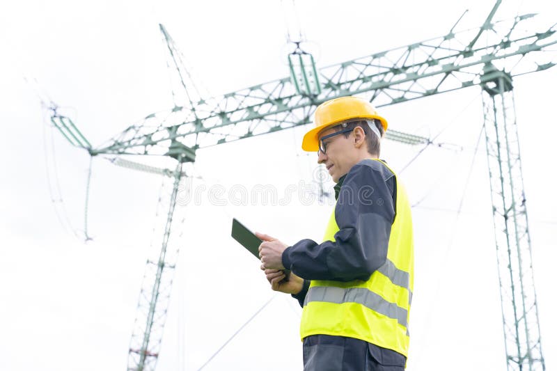 Engineer with Digital Tablet on a Background of Power Line Tower Stock ...
