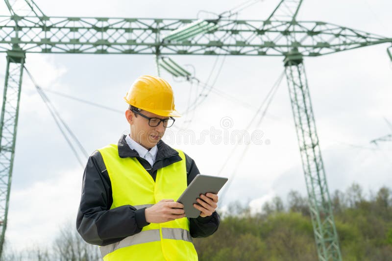 Engineer with Digital Tablet on a Background of Power Line Tower. Stock ...