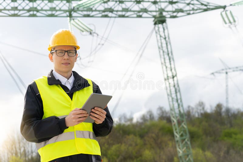 Engineer with Digital Tablet on a Background of Power Line Tower Stock ...