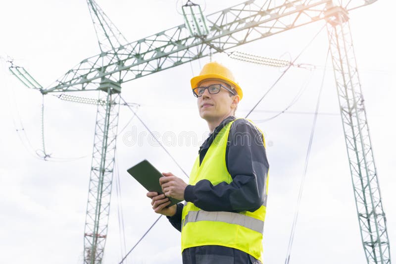 Engineer with Digital Tablet on a Background of Power Line Tower. Stock ...