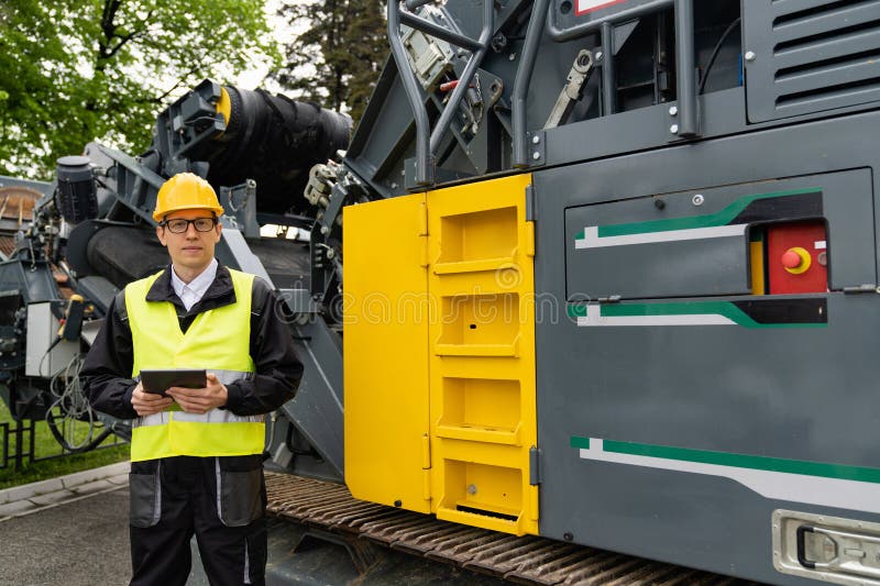 Engineer with Digital Tablet Next To Road Construction Machine Stock ...
