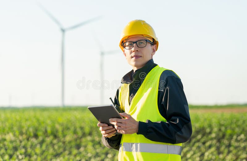 Engineer with Digital Tablet Works on a Field of Wind Turbines Stock ...