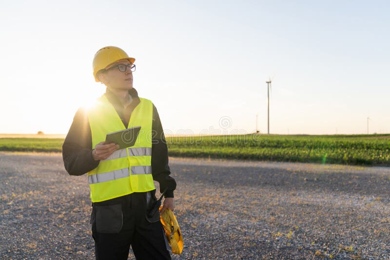 Engineer with Digital Tablet Works on a Field of Wind Turbines Stock ...