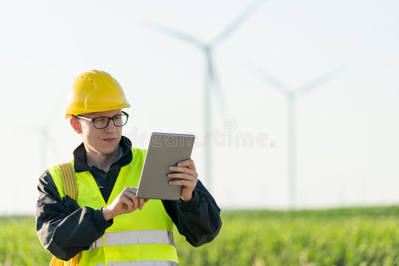 Engineer with Digital Tablet Works on a Field of Wind Turbines Stock ...