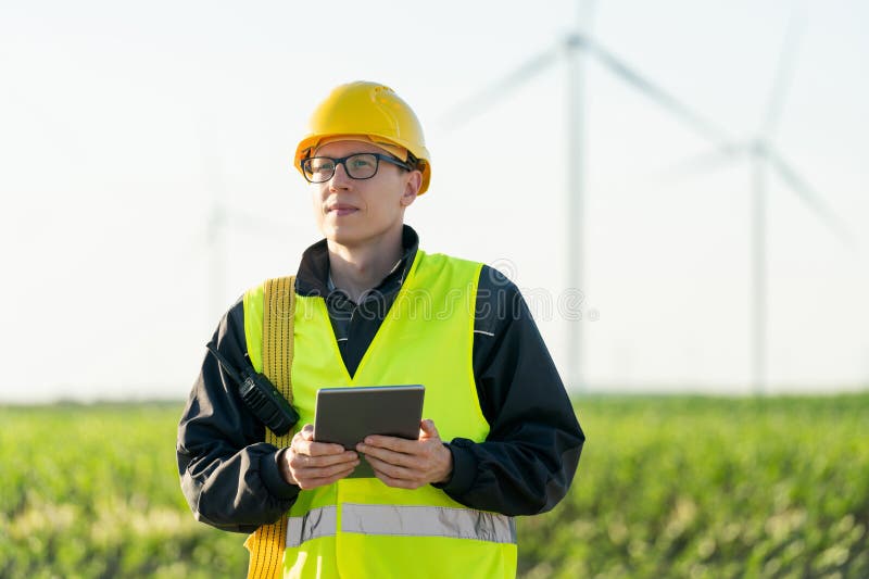 Engineer with Digital Tablet Works on a Field of Wind Turbines Stock ...