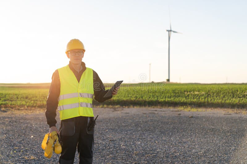 Engineer with Digital Tablet Works on a Field of Wind Turbines Stock ...