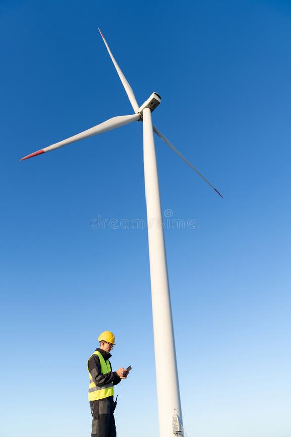 Engineer with Digital Tablet Works on a Field of Wind Turbines Stock ...