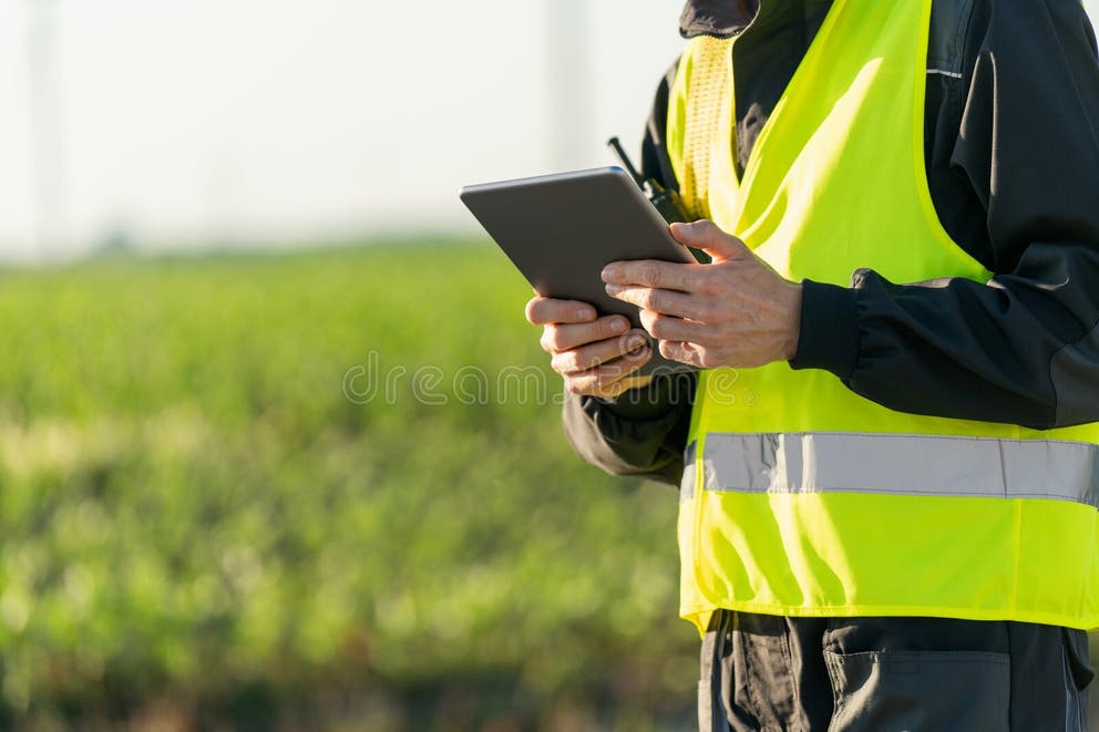 Engineer with Digital Tablet Works on a Field of Wind Turbines Stock ...