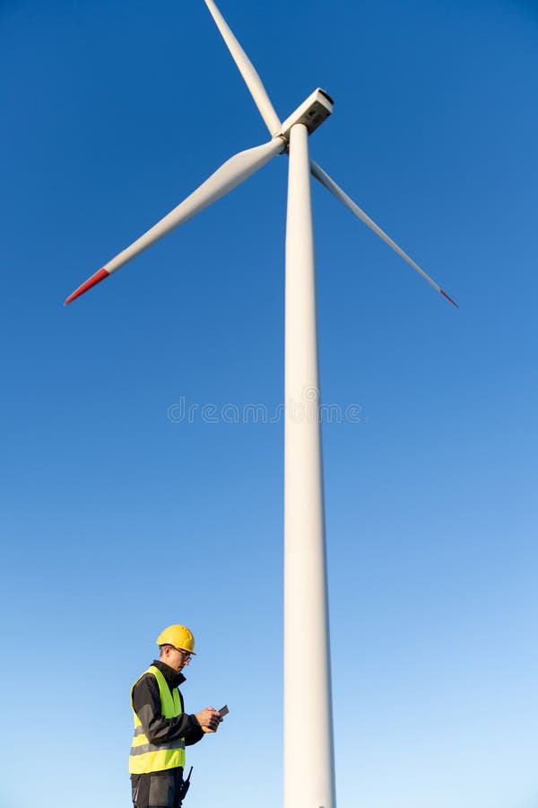Engineer with Digital Tablet Works on a Field of Wind Turbines Stock ...