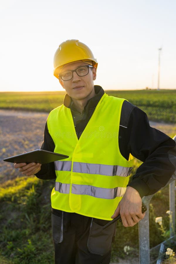 Engineer with Digital Tablet Works on a Field of Wind Turbines Stock ...