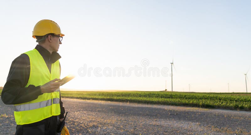 Engineer with Digital Tablet Works on a Field of Wind Turbines Stock ...