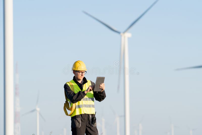 Engineer with Digital Tablet Works on a Field of Wind Turbines Stock ...