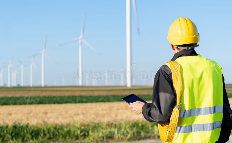 Engineer with Digital Tablet Works on a Field of Wind Turbines Stock ...