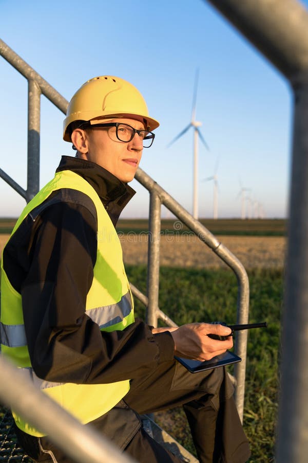 Engineer with Digital Tablet Works on a Field of Wind Turbines Stock ...