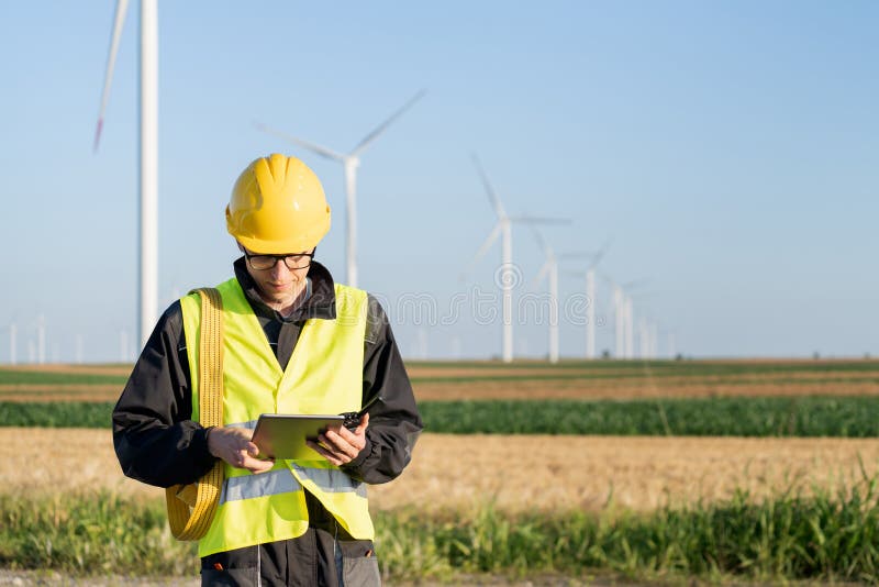 Engineer with Digital Tablet Works on a Field of Wind Turbines Stock ...