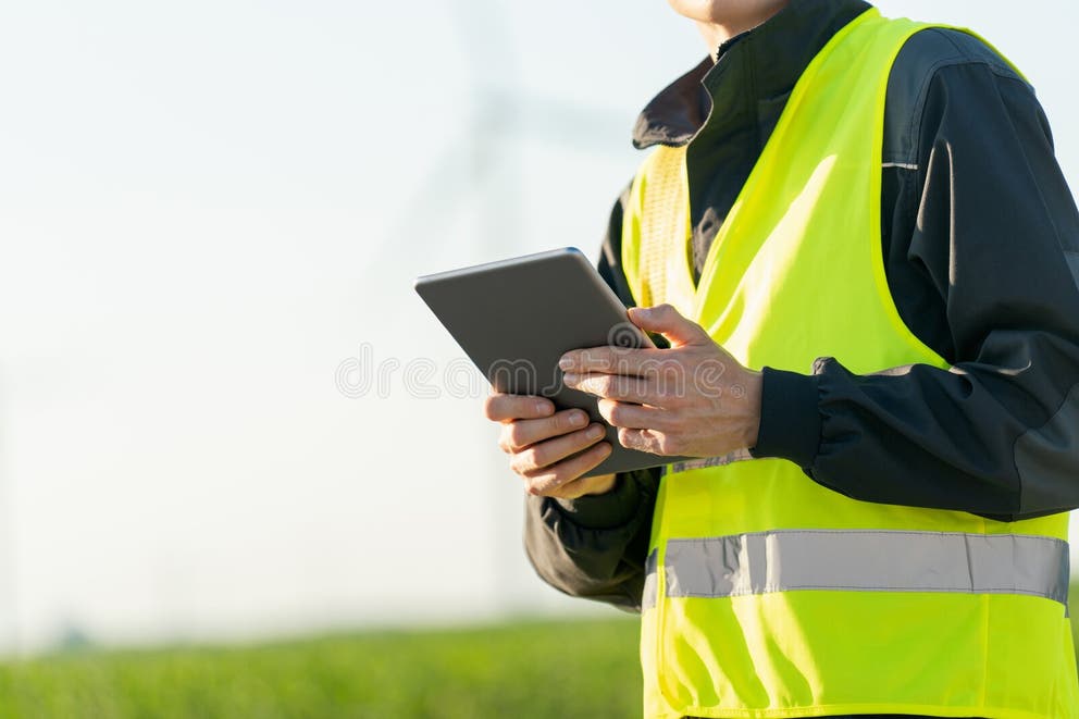 Engineer with Digital Tablet Works on a Field of Wind Turbines Stock ...