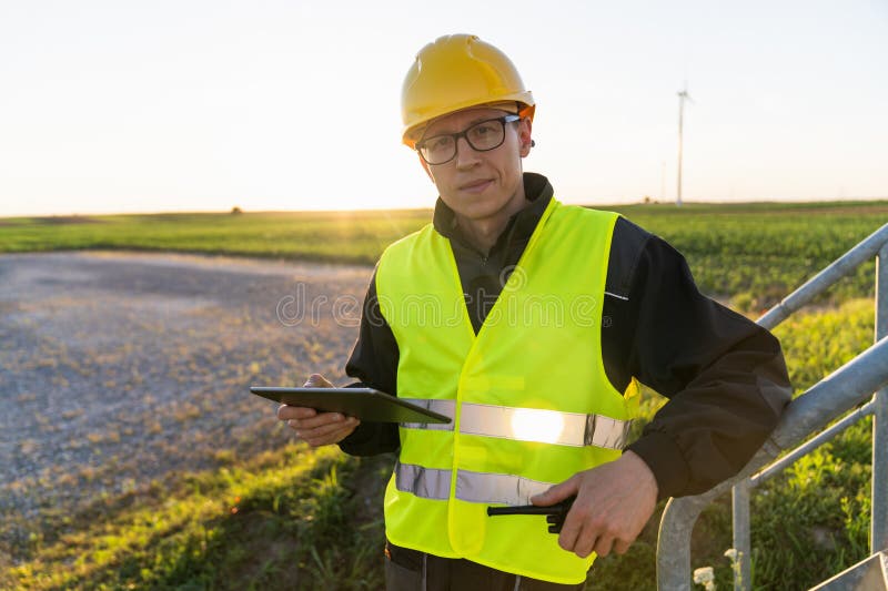 Engineer with Digital Tablet Works on a Field of Wind Turbines Stock ...