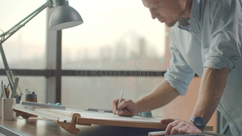 Engineer Draws Buildings on the Table Using a Pencil and Ruler. an ...