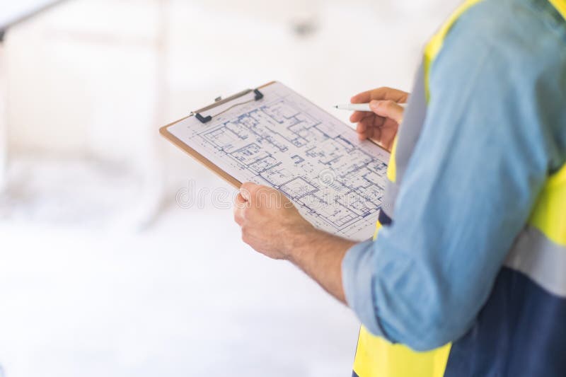 Engineer Examining Construction Documentation Holding Clipboard and Pen ...