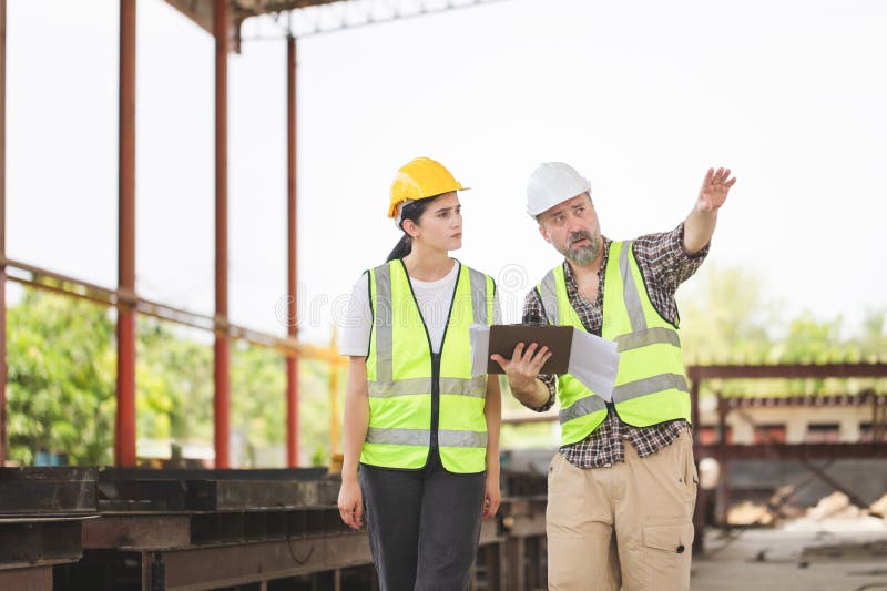 Engineer and Female Foreman Worker with Blueprints Checking Project at ...