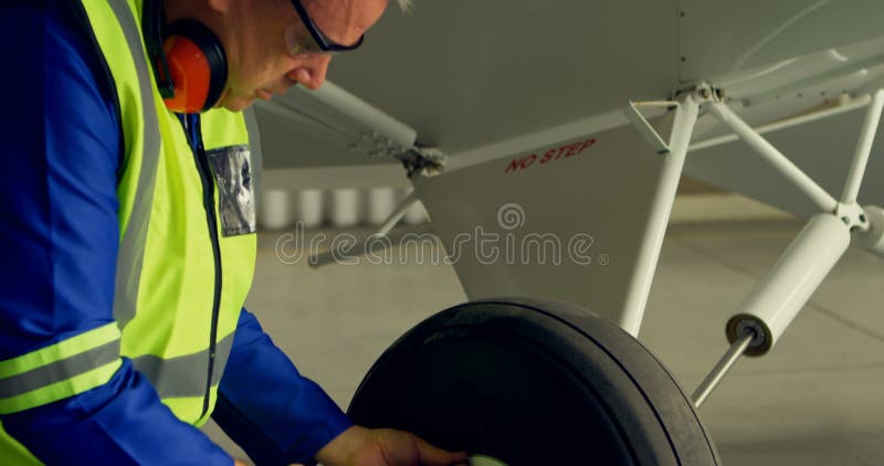 Engineer Fixing a Wheel of Aircraft 4k Stock Video - Video of high ...