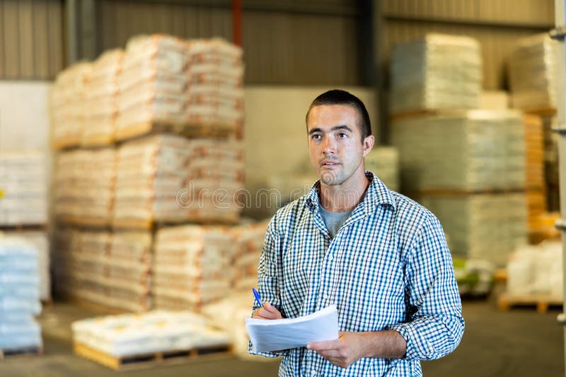 Engineer or Foreman Holding Documents and Checking Inventory or Job ...