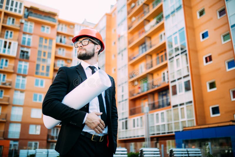 Engineer in Front of Modern Building with Plan Looking at Blueprint ...