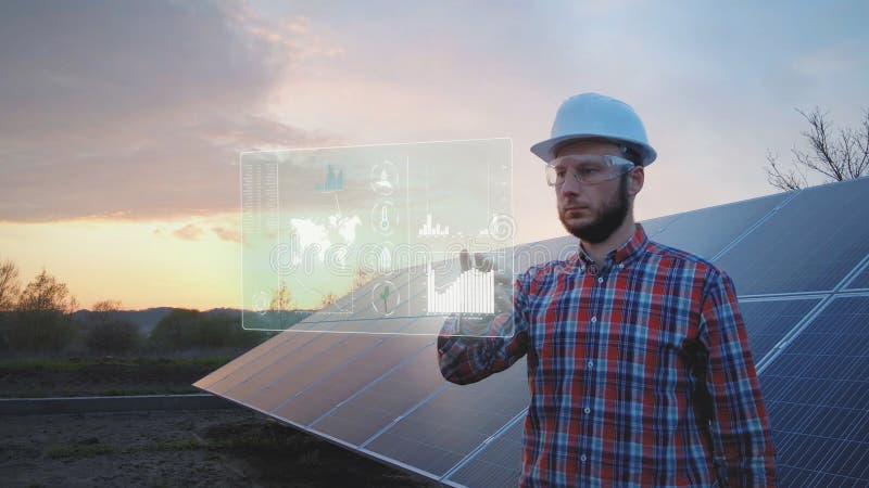 Engineer in Front of Solar Panel Works on Futuristic Table HUD Display ...