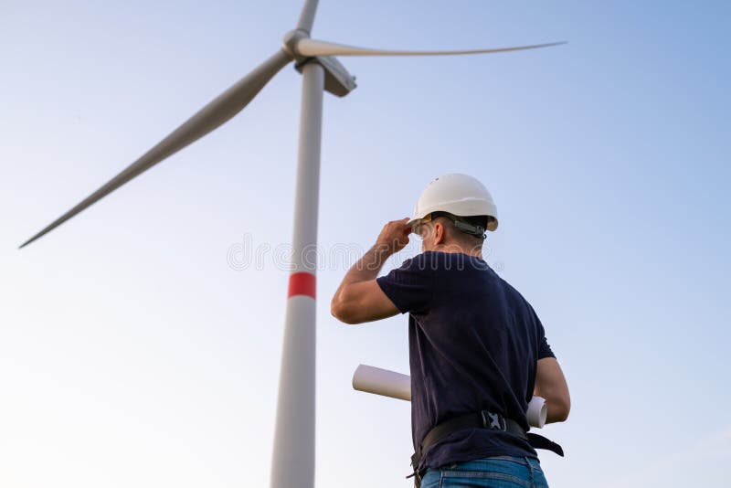 Engineer in Hard Hat Holds a Plan Project for the Construction of Wind ...