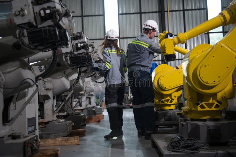 Engineer Standing by Robotic Arm and Operating Machine in Industry ... Engineer Standing by Robotic Arm and Operating Machine in Industry ...