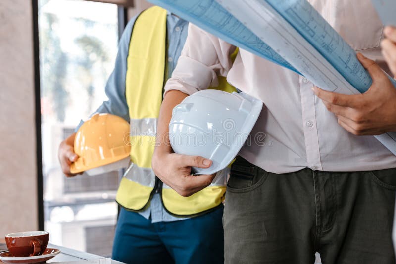 Engineer Hold Engineer Drawing Design Blueprints and Safety Helmet in ...