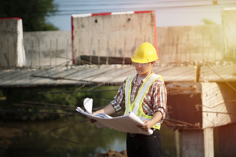 Engineer Holding Blueprint in Construction Site Stock Photo - Image of ...