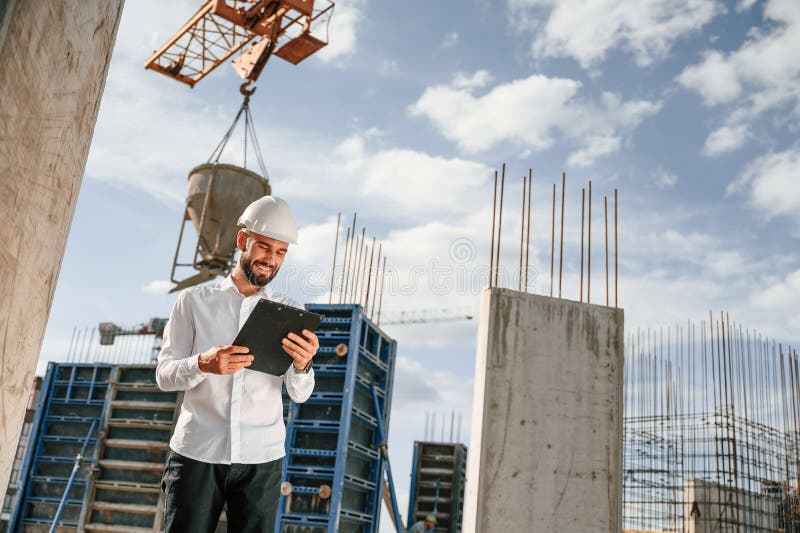 Engineer is Holding Notepad. Man in Uniform is Working on the ...