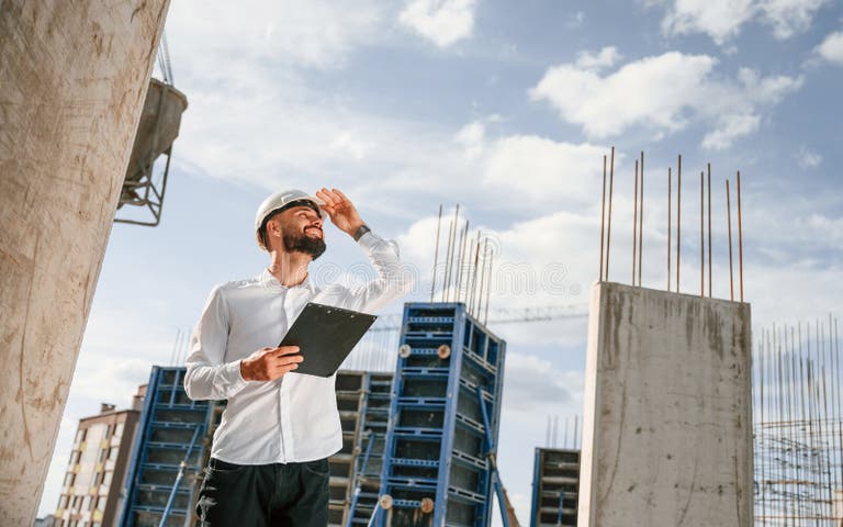 Engineer is Holding Notepad. Man in Uniform is Working on the ...